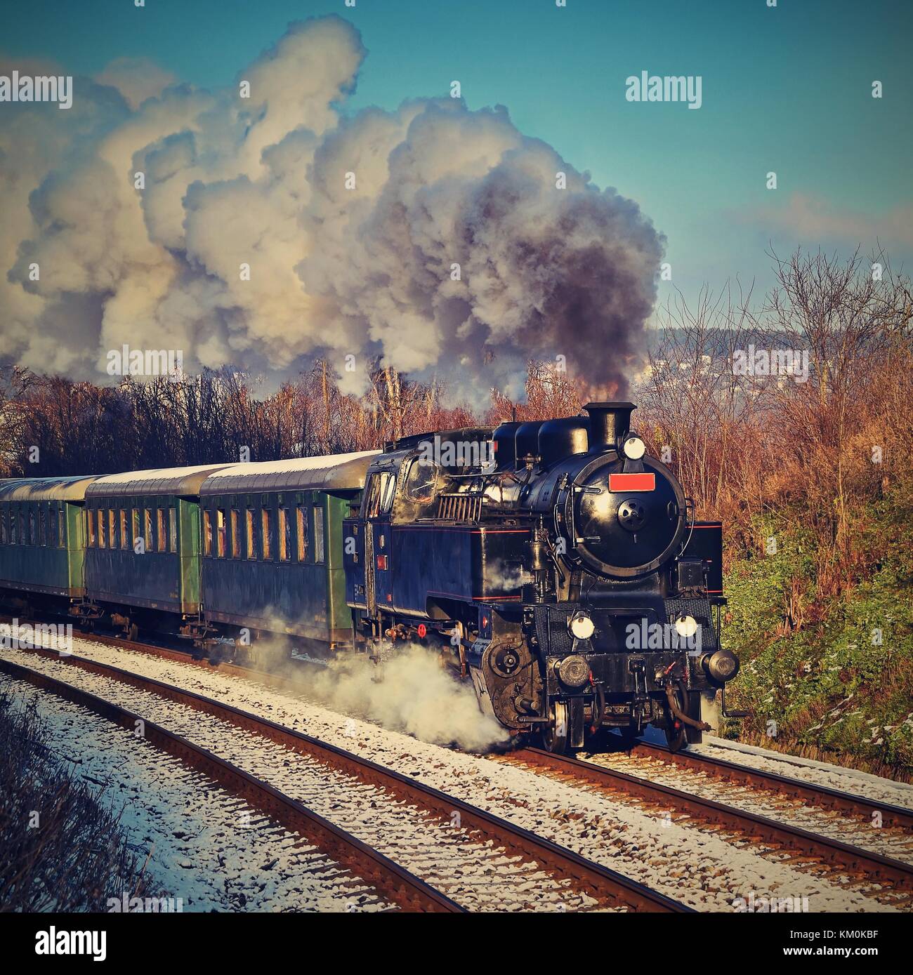 Beautiful old steam train with wagons running on rails at sunset ...