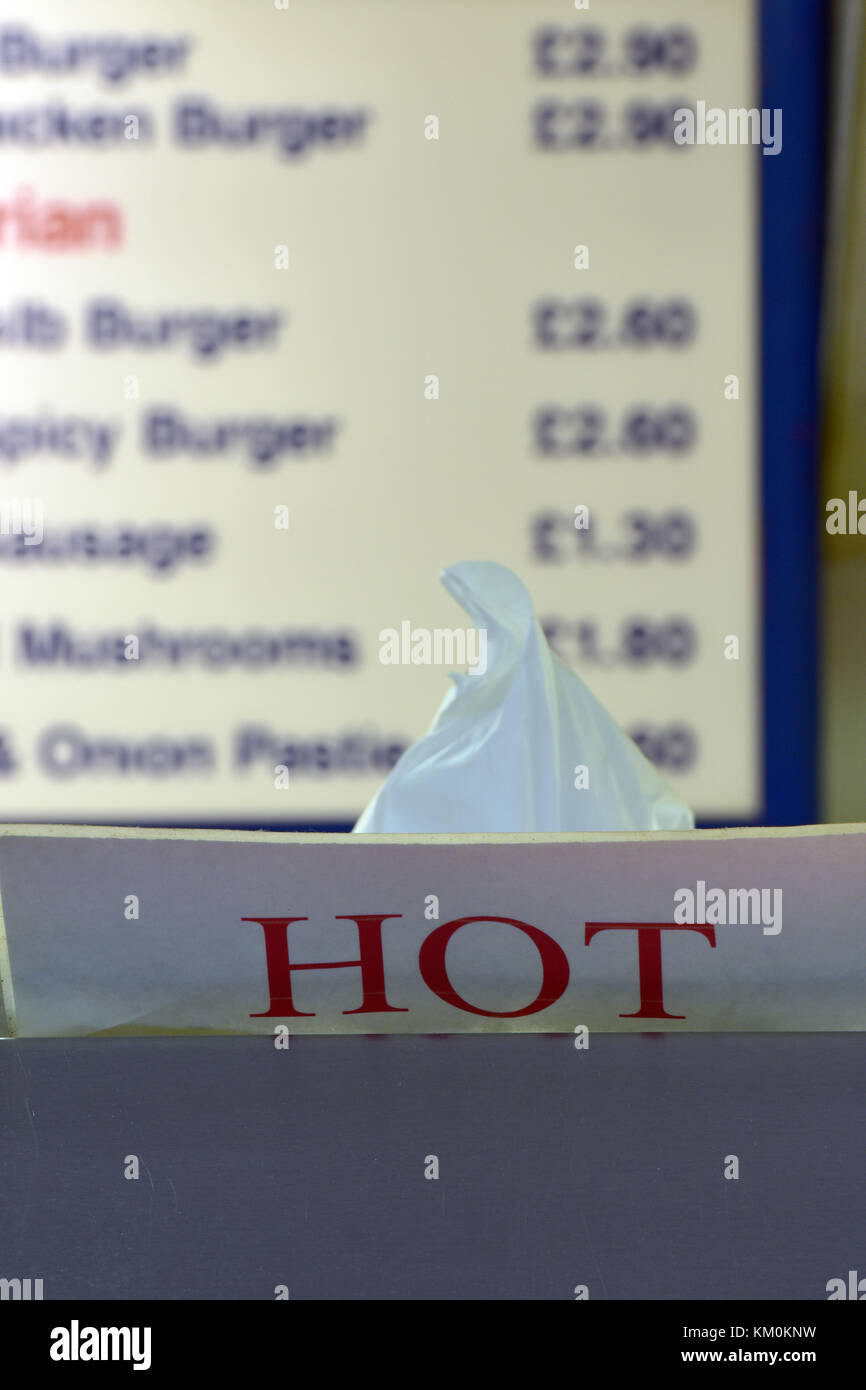 A hot sign written in red with a menu on the wall and some fish and ...