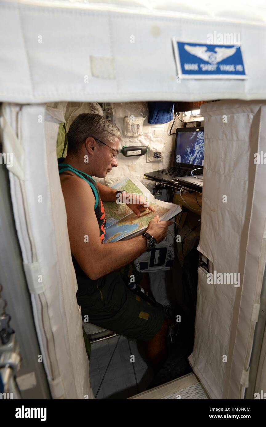 Expedition 53 American astronaut Mark Vande Hei looks through an atlas ...
