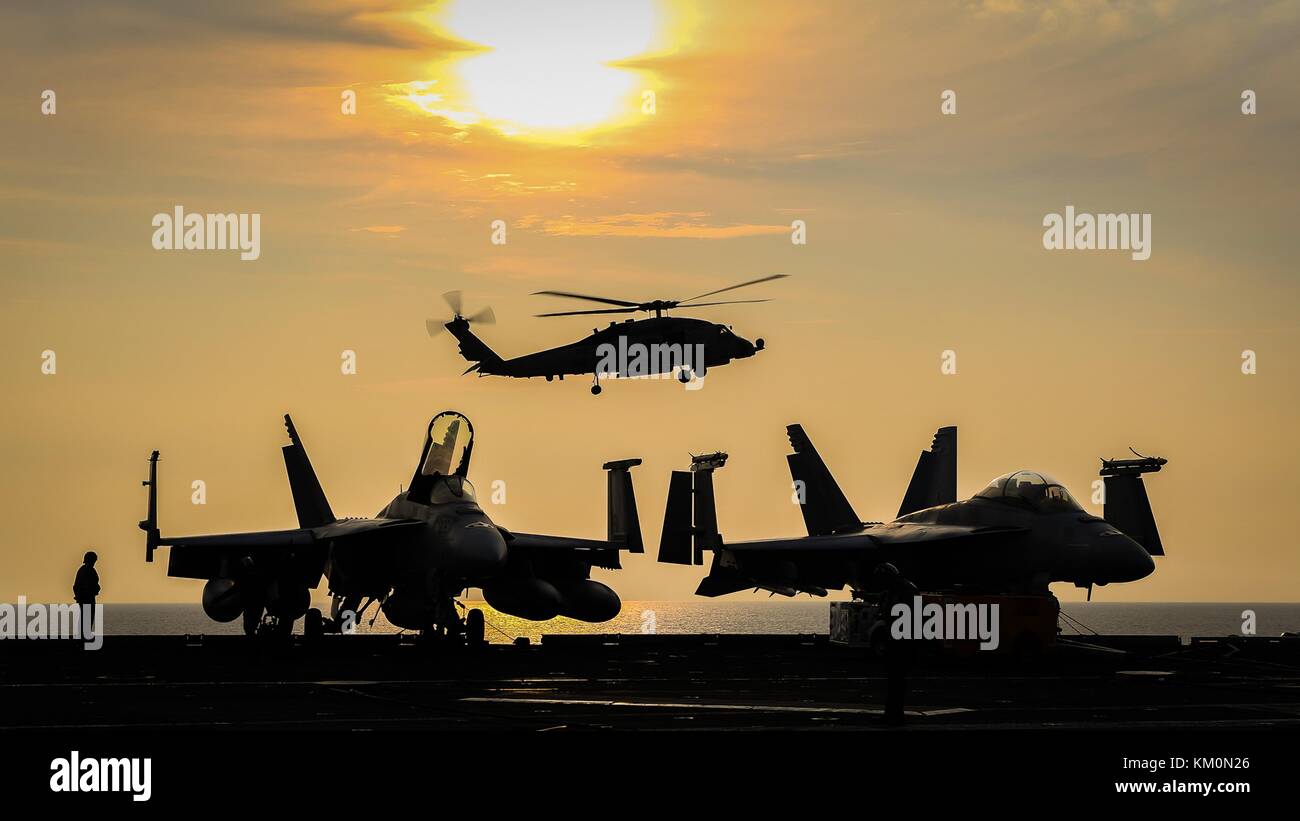A U.S. Navy MH-60S Seahawk helicopter lands on the flight deck of the U ...