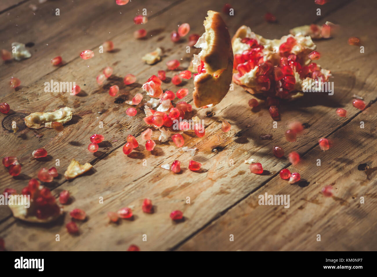 Falling down ripe pomegranate with cracks and splashes of juice and ...