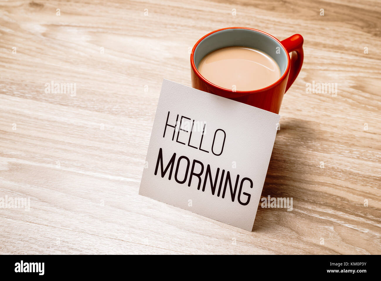 Hello Monday quote wrote on red coffee cup and post it on wood table ...