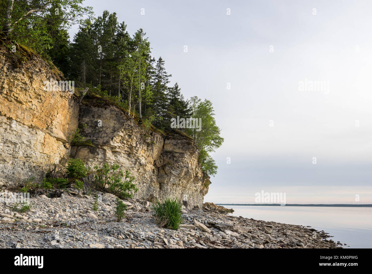Sunset on the beach. Limestone cliff in the sea under blue sky and ...