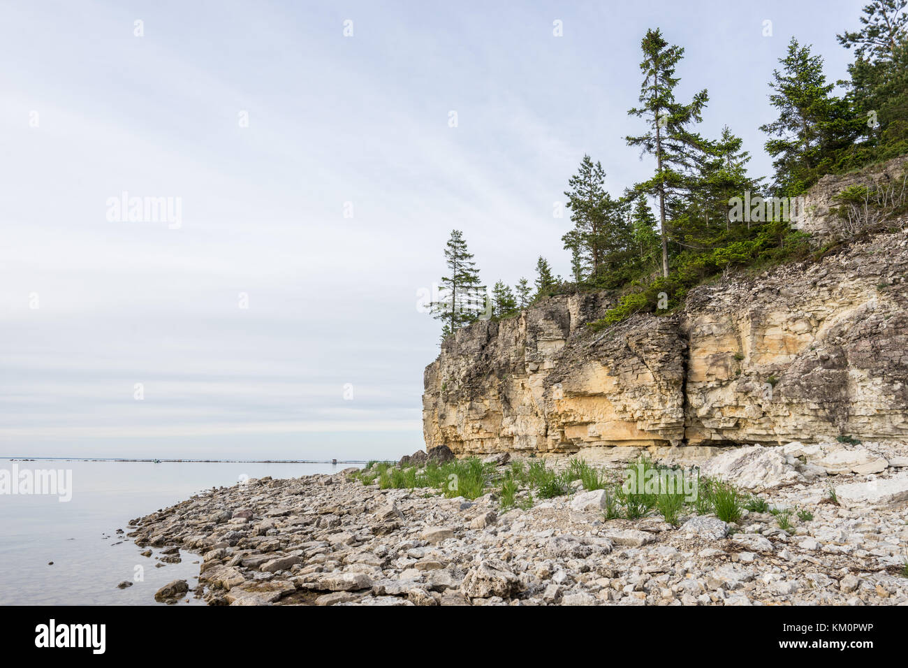 Sunset on the beach. Limestone cliff in the sea under blue sky and ...