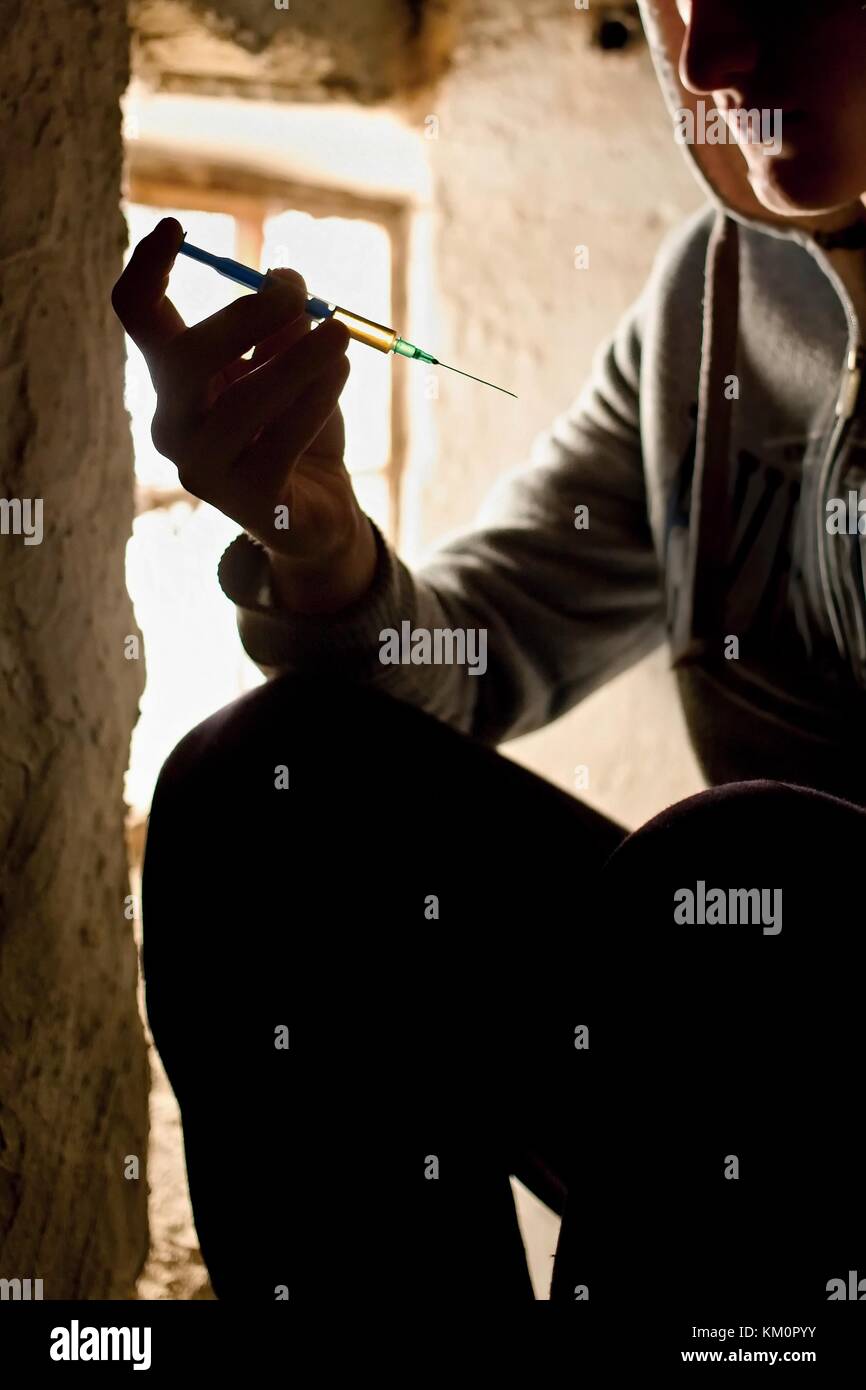 Drugs concept. Disease concept. Drug addict man with syringe using ...