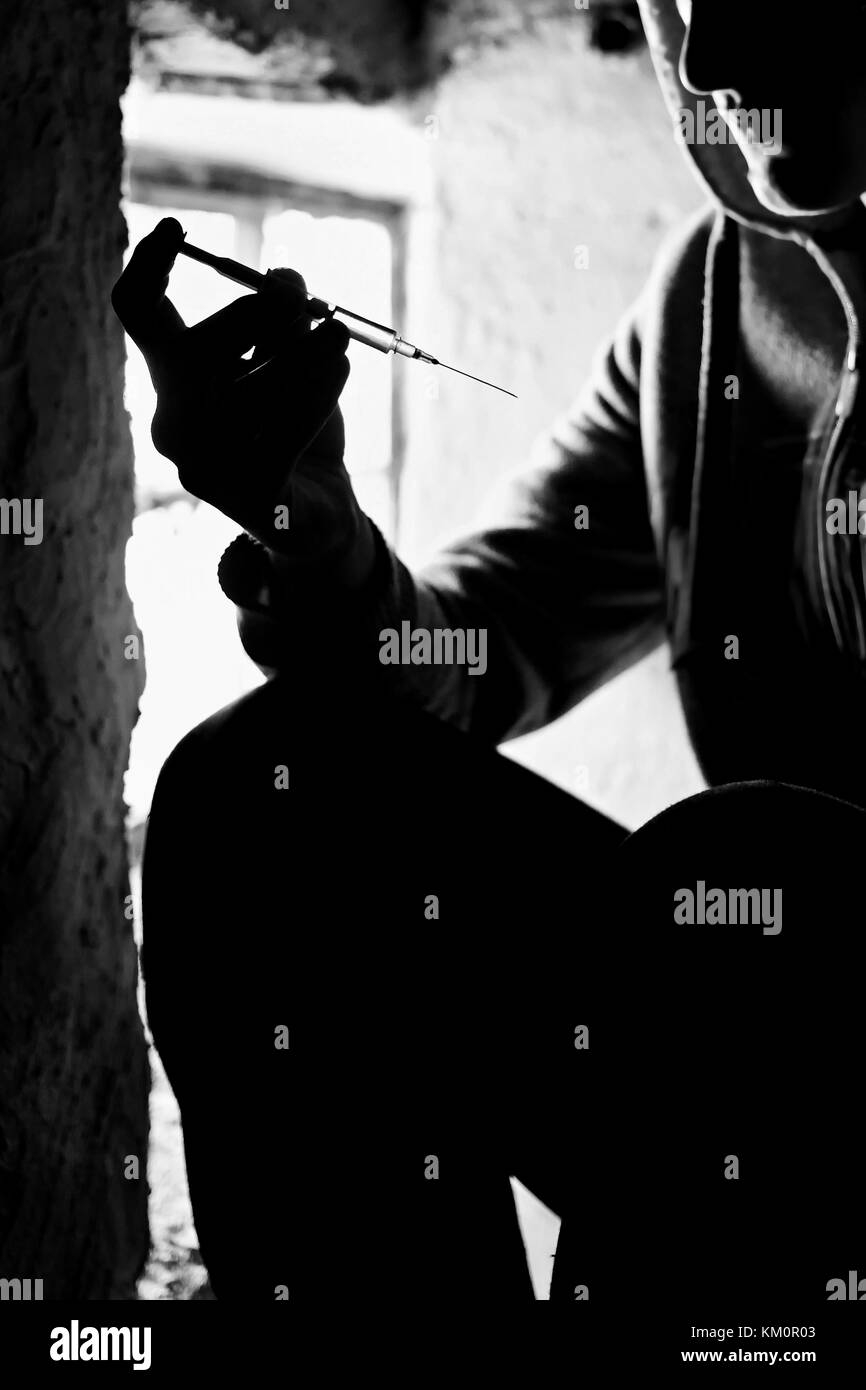 Drugs concept. Disease concept. Drug addict man with syringe using ...