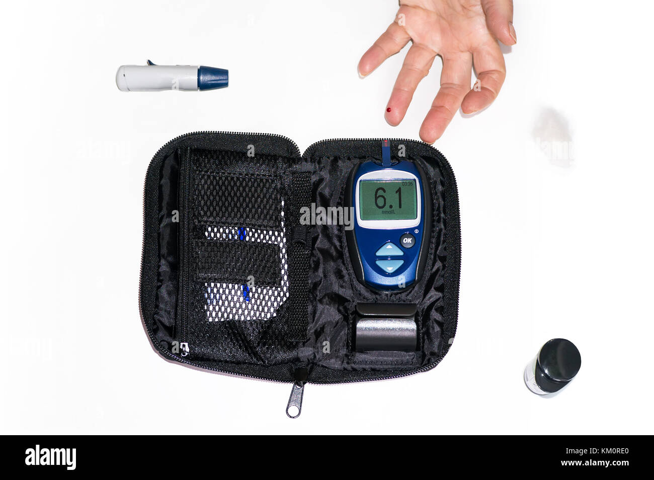 woman's hand. display of glucometer showing number 6.1, on white ...