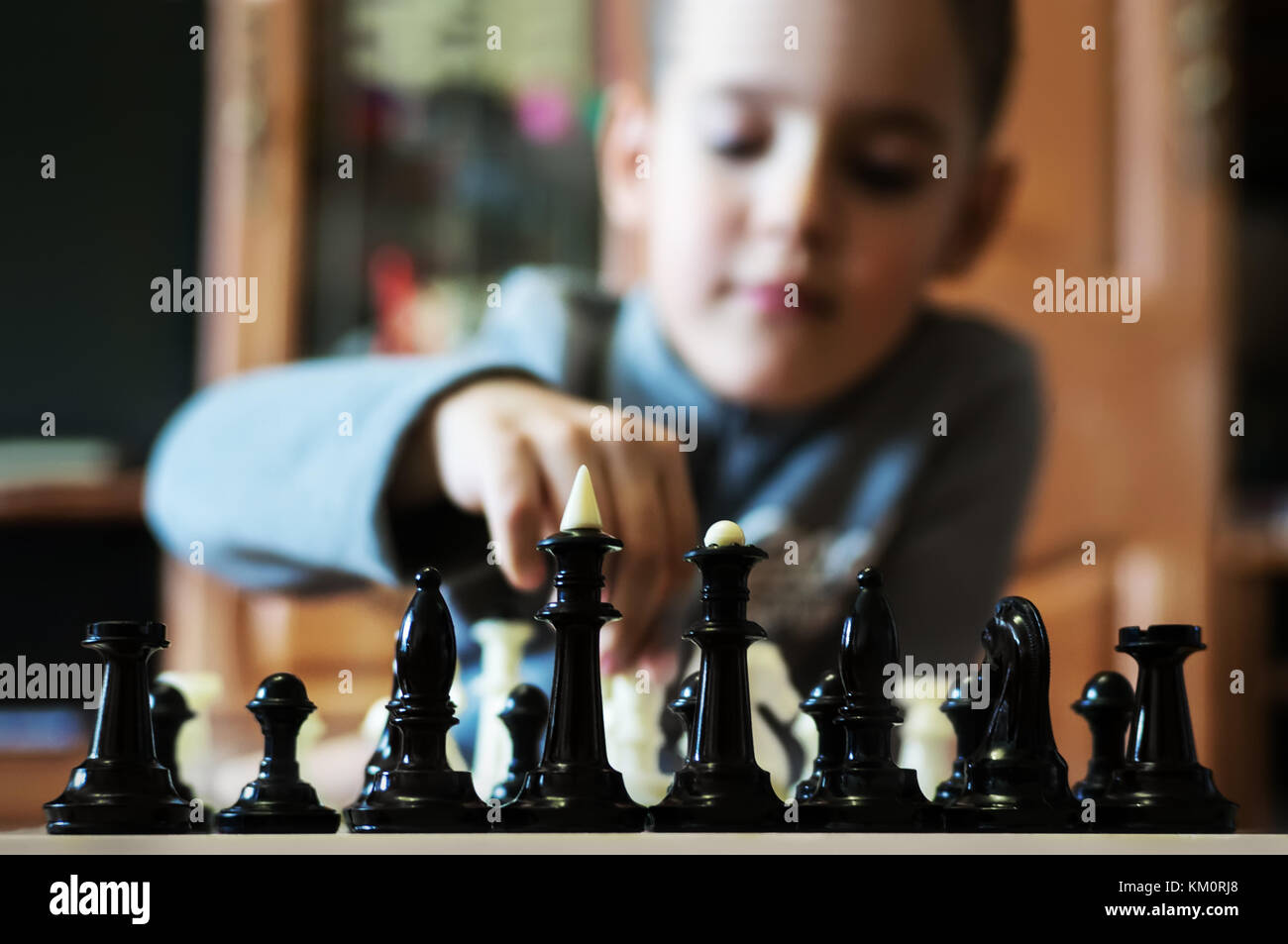 Cute little boy playing chess. The child makes a move chess. home ...