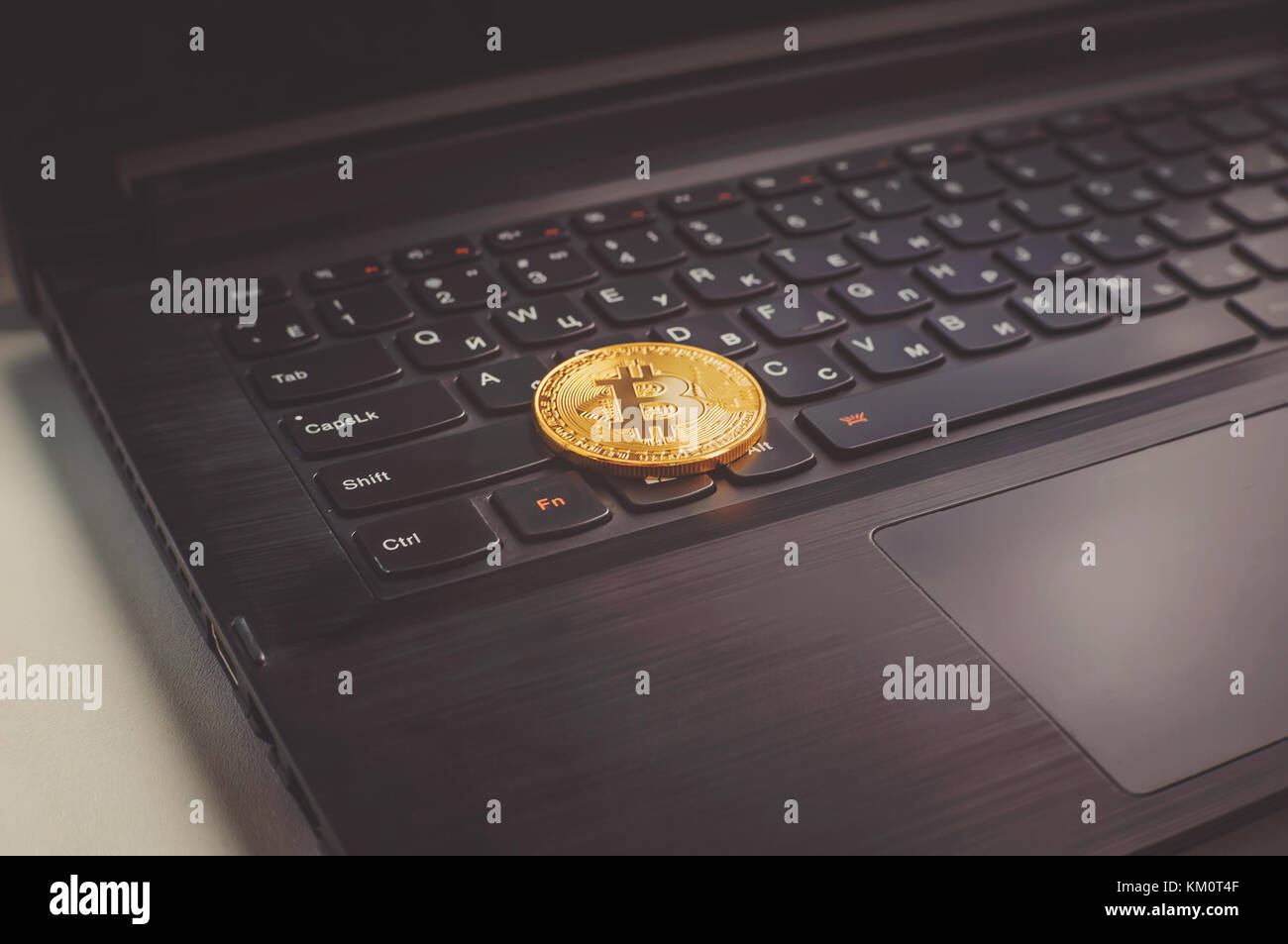 Bitcoin physical coin symbol on black keyboard. The electronic coin ...