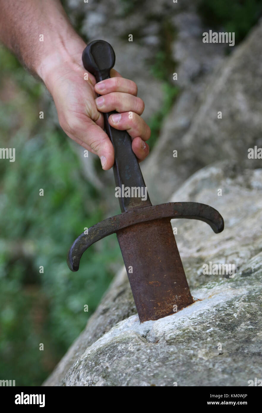 mighty hand trying to draw the sword into the rock Stock Photo - Alamy