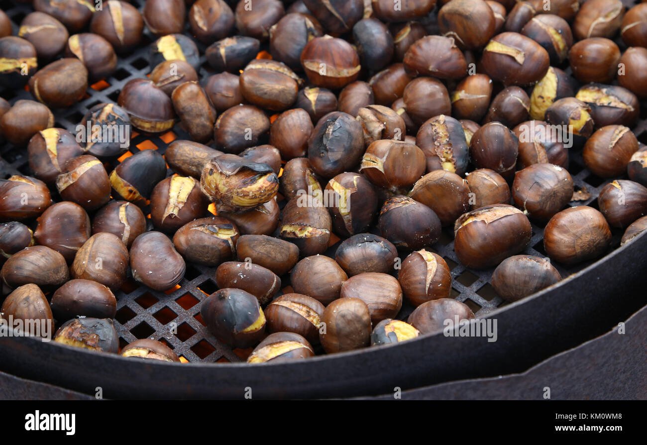 roast chestnuts cooked over the red-hot grill on the cold end of autumn ...