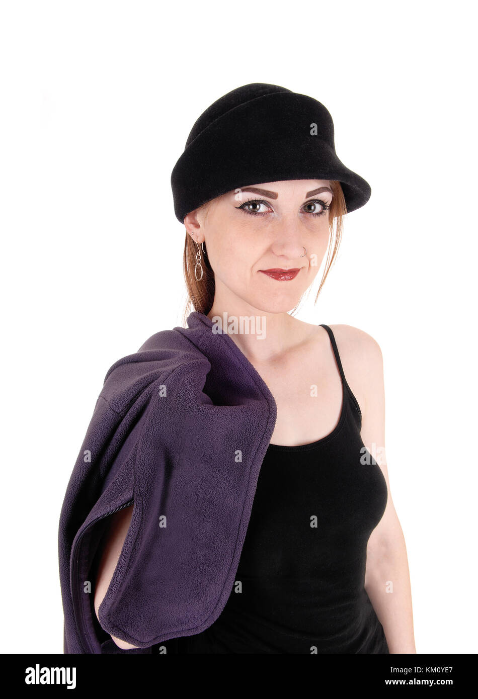 A beautiful woman with a hat and her winter coat over her shoulder ...