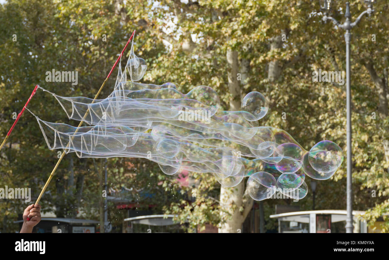 Blowing multiple iridescent round bubbles with soap, water, bamboo ...