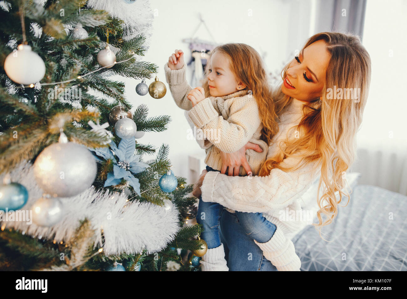 mother and daughter decorating the tree Stock Photo - Alamy