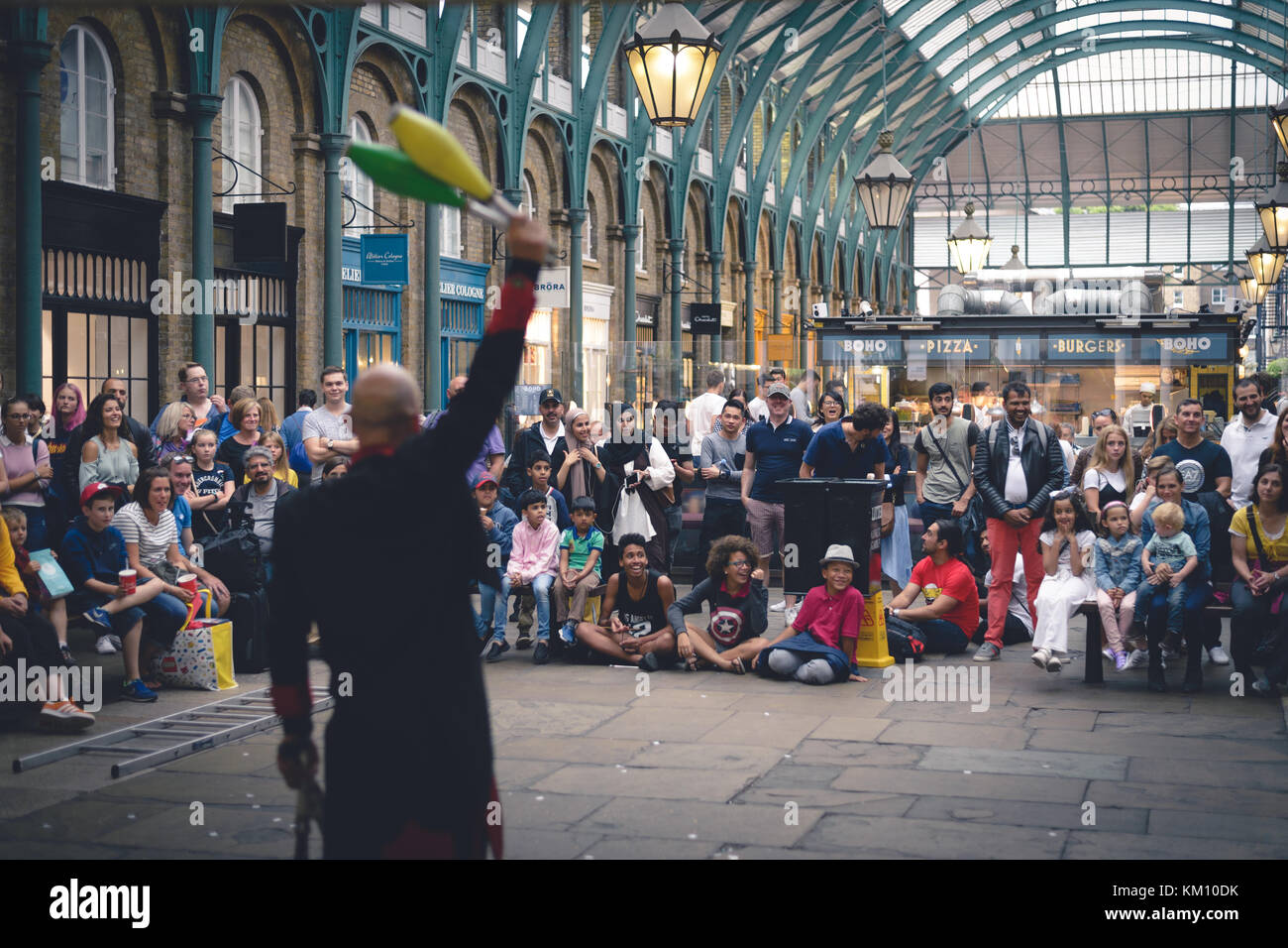 Crowd assisting a show of a street juggler in Covent Garden in London ...