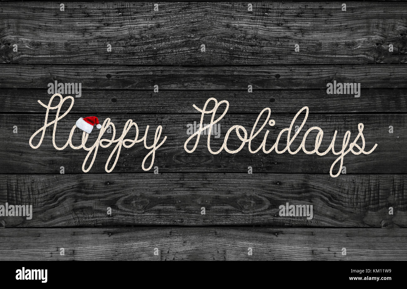 happy holidays greeting text in rope design on rustic black wood with ...