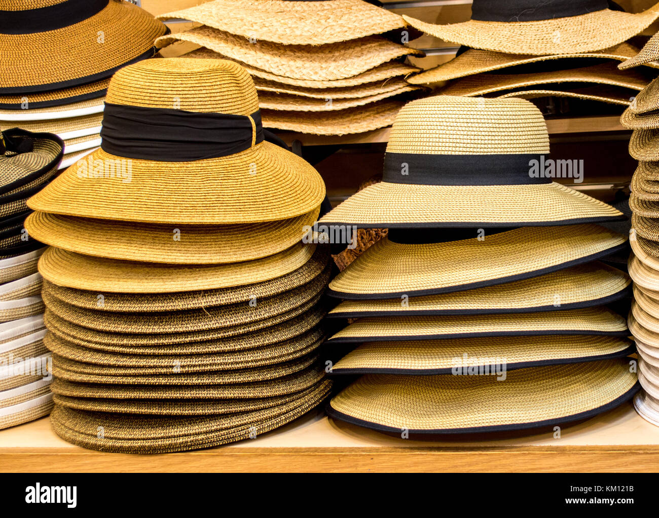 rows of colorful sun hats and Panama hats stacked on shelves in a hat ...