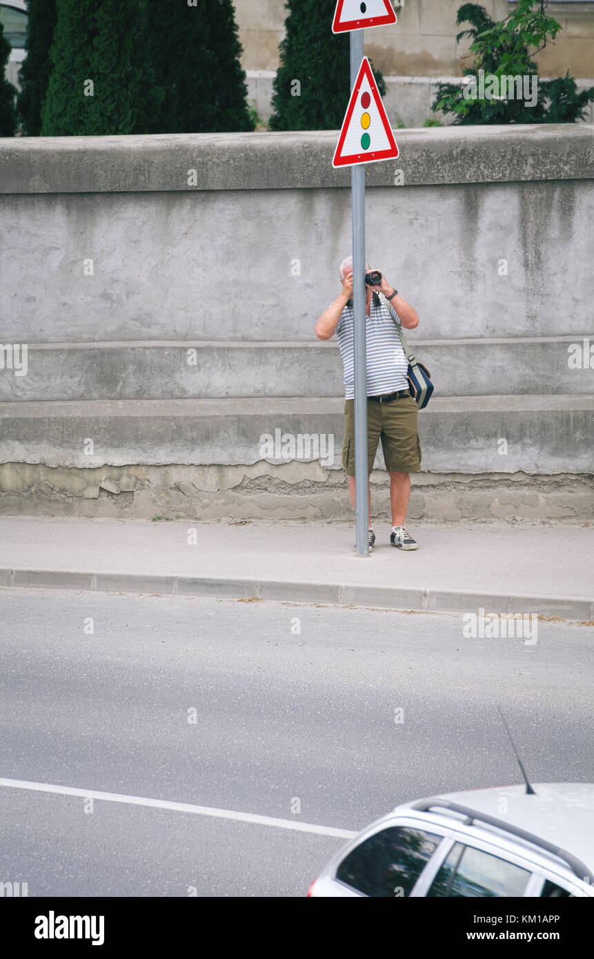 Old Tourist Man Taking Photo behind the Signpost on the Street Stock ...
