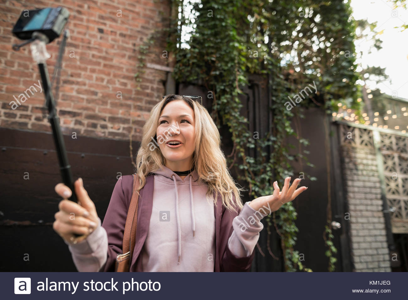 Woman holding selfie stick hi-res stock photography and images - Alamy
