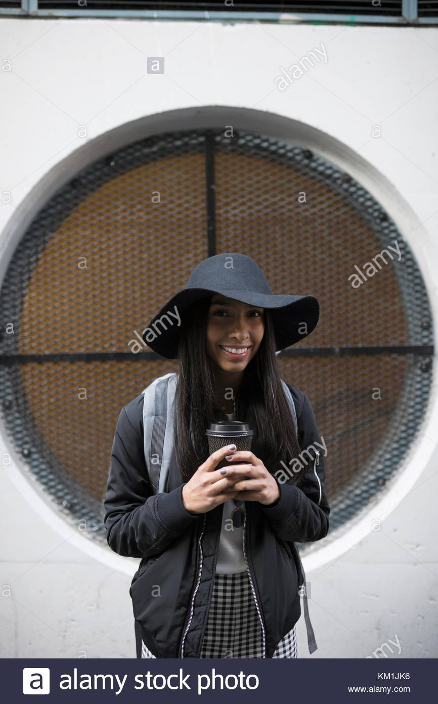 Portrait smiling, confident young woman in hat drinking coffee Stock ... Portrait smiling, confident young woman in hat drinking coffee Stock ...
