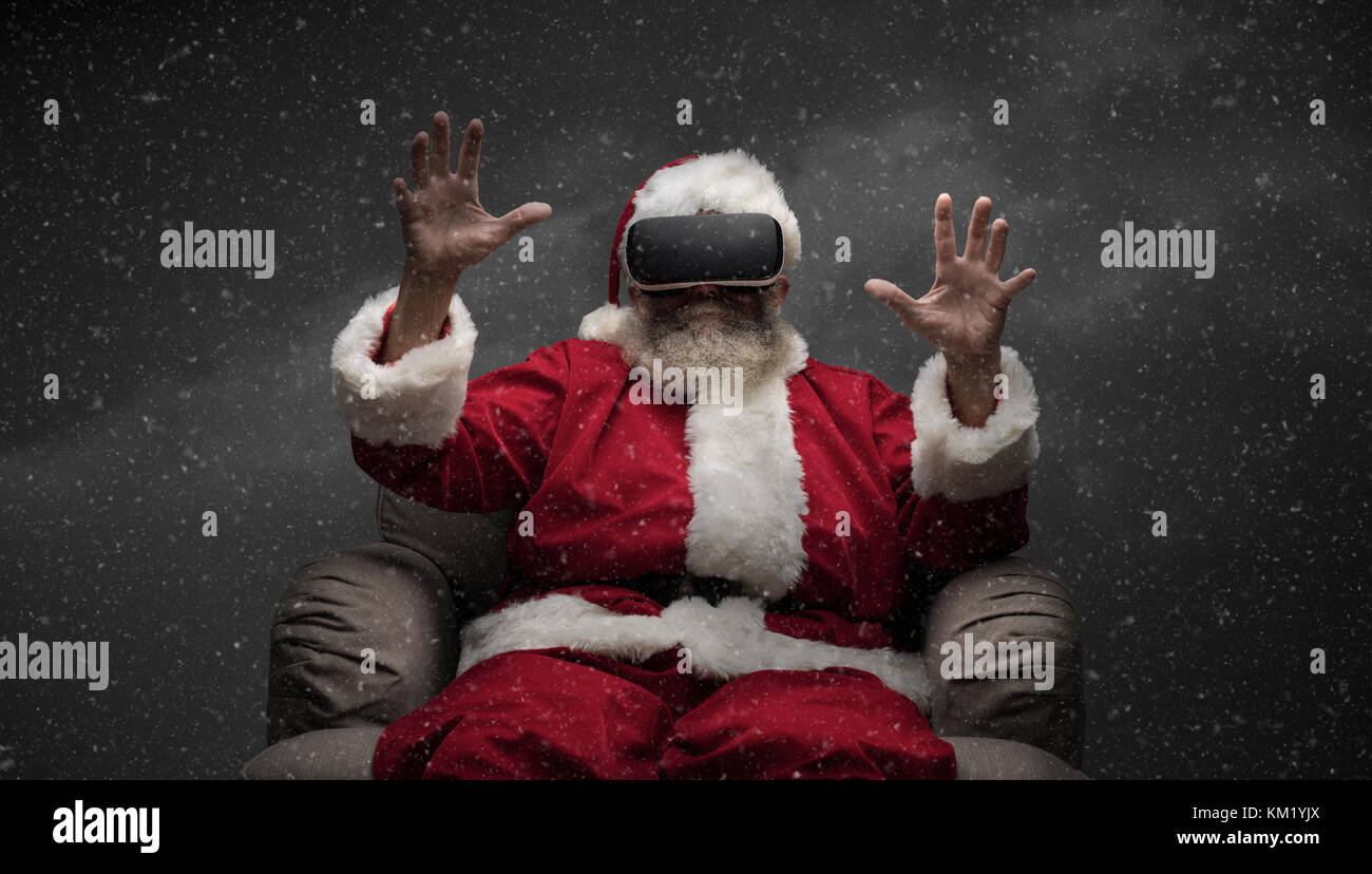 Santa Claus experiencing virtual reality, he is wearing VR glasses and ...