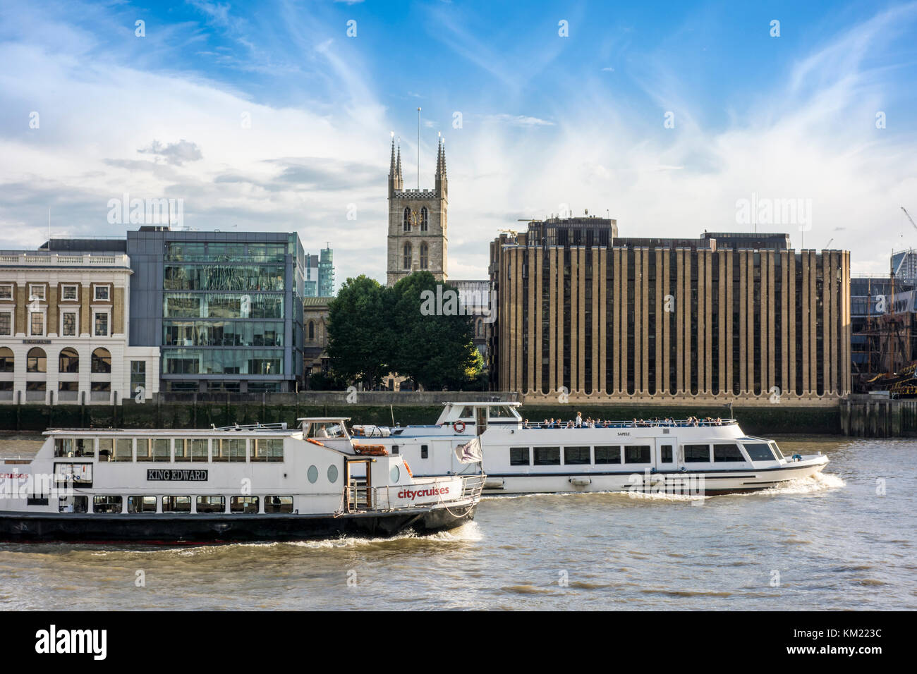 Two tour cruise boats on the river Thames and a view of the southbank ...
