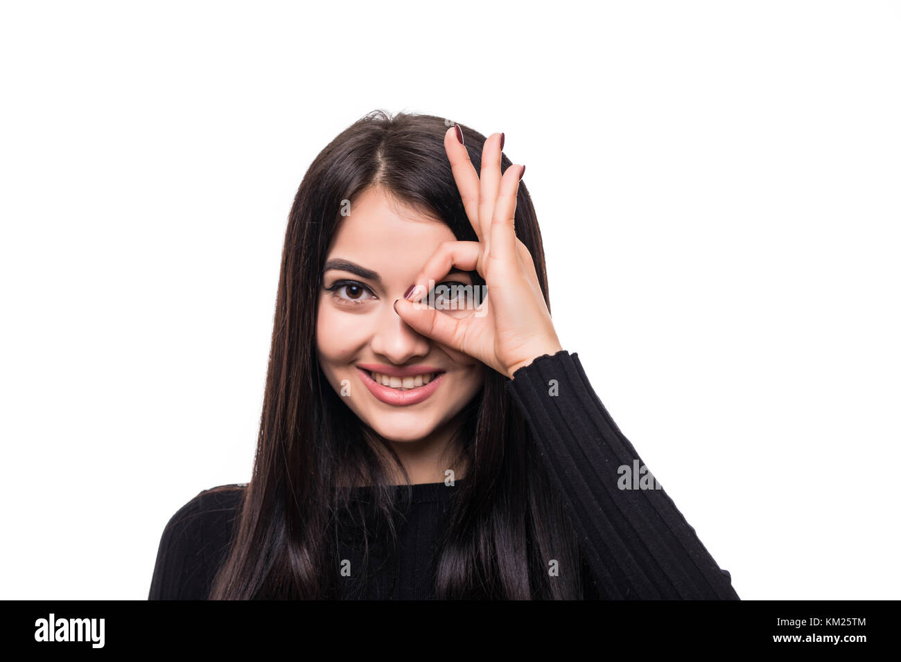 Photo of happy young lady standing isolated over white background. Looking camera showing okay ...