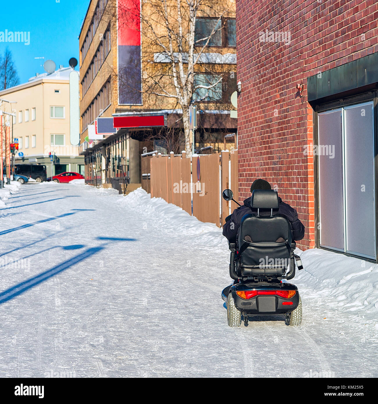 Disabled man in automatic wheelchair crossing the street of winter ...