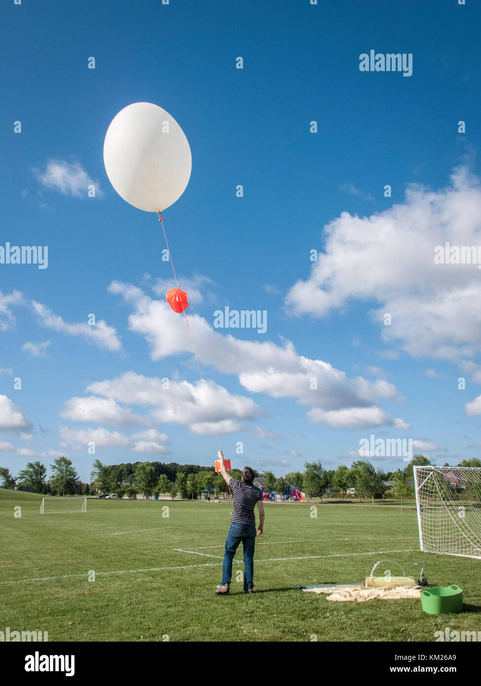 Man launching a high altitude weather balloon with scientific payload ...