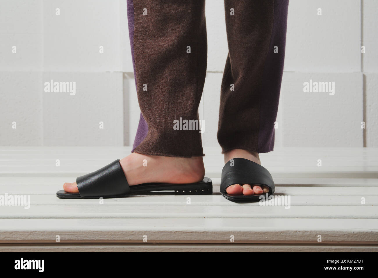 Female legs in leather slippers Stock Photo - Alamy