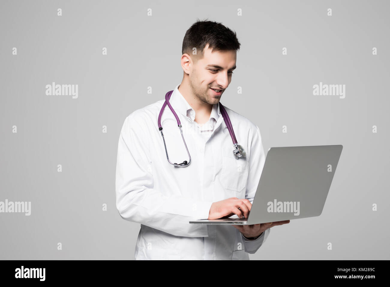Happy Doctor Using Laptop Over White Background Stock Photo - Alamy