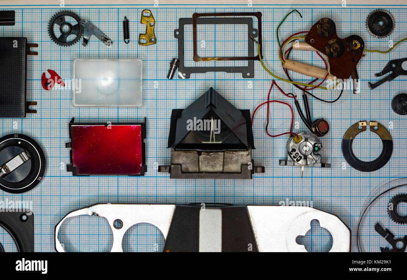 parts are completely disassembled old retro film SLR camera on graph ...