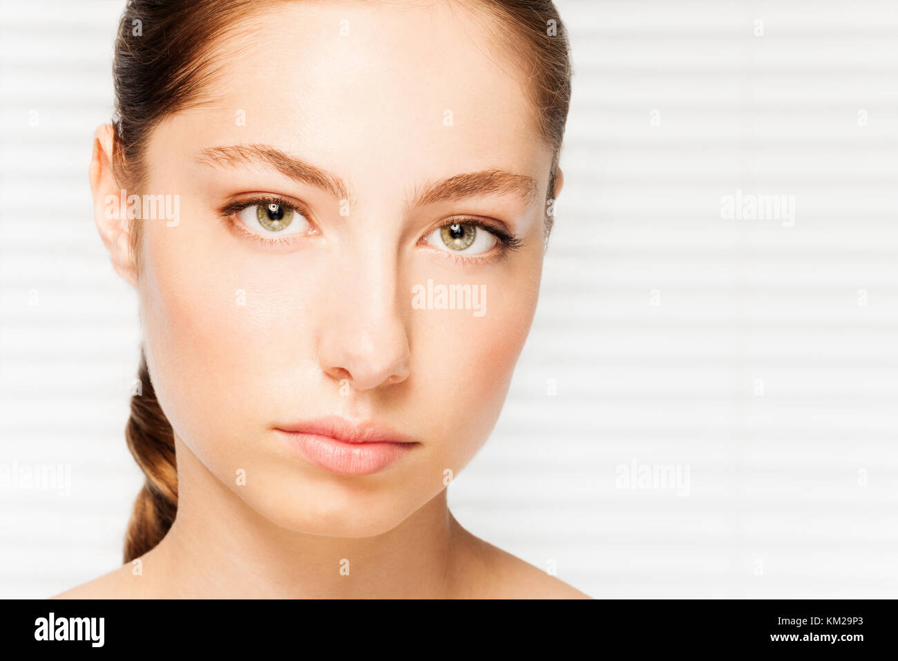 Close-up portrait of dark-haired woman with clean skin face looking ...