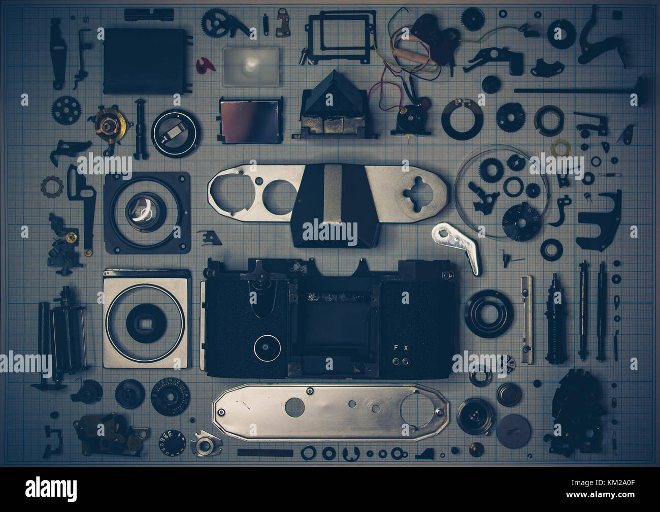 parts are completely disassembled old retro film SLR camera on graph ...