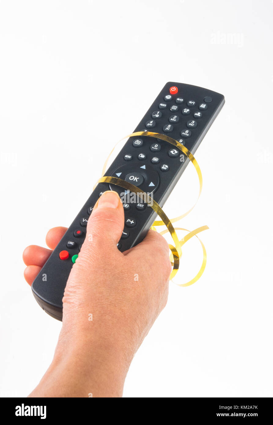 hand holding a remote control in a festive gold ribbon on white ...
