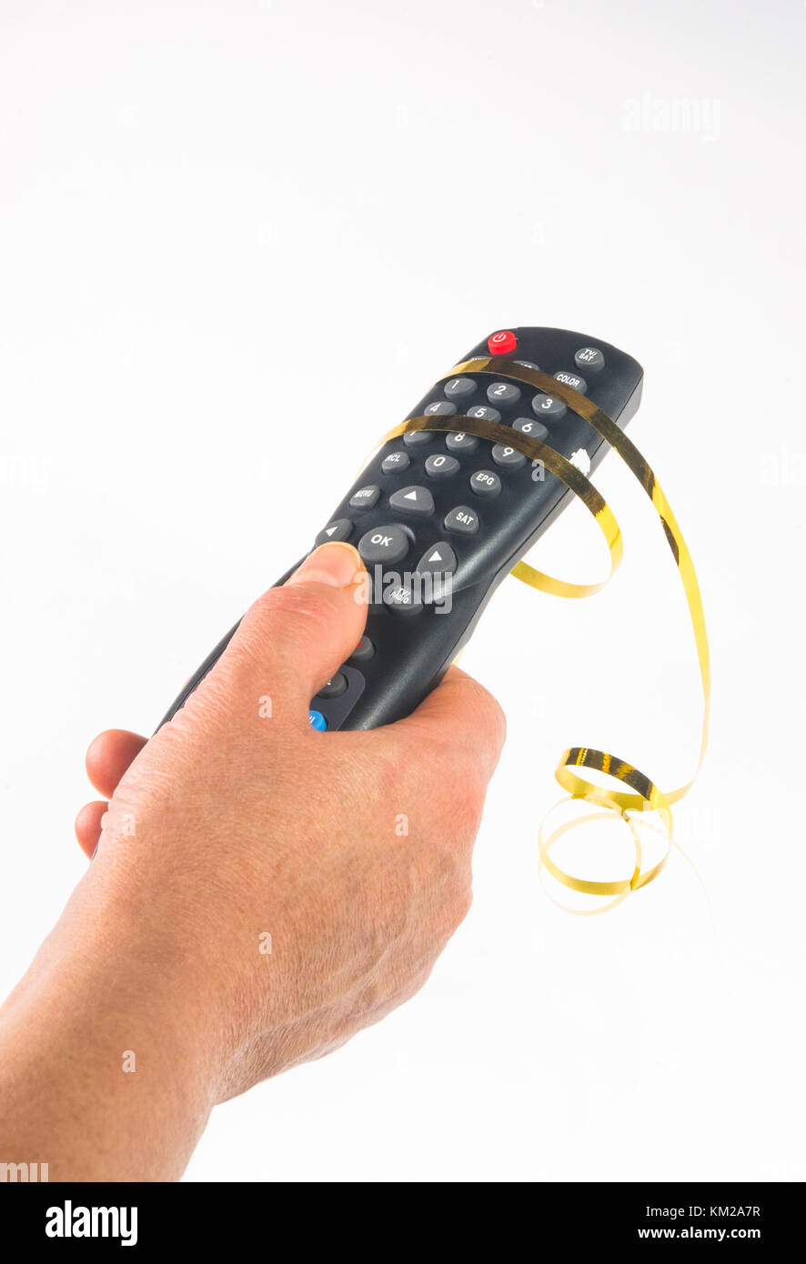 hand holding a remote control in a festive gold ribbon on white ...