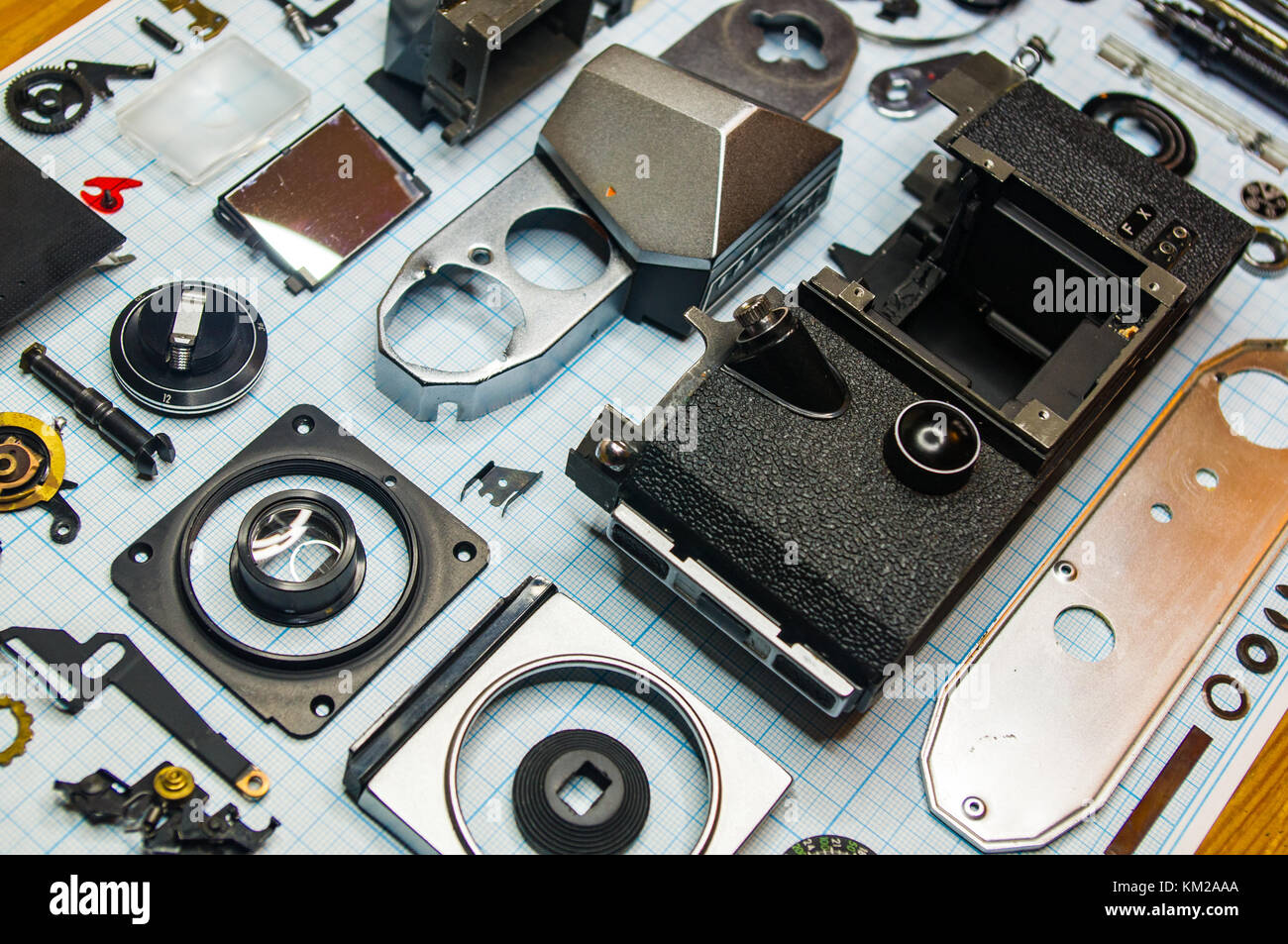 parts are completely disassembled old retro film SLR camera on graph ...