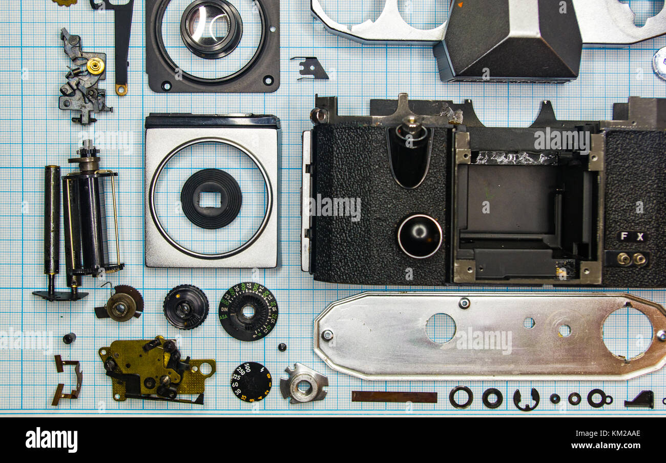 parts are completely disassembled old retro film SLR camera on graph ...