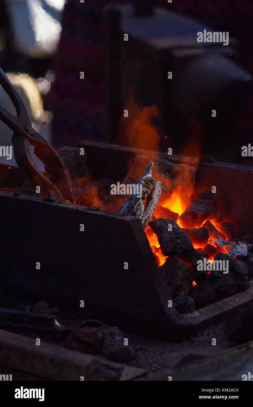 blacksmith furnace with burning coals, tools, and glowing hot metal ...