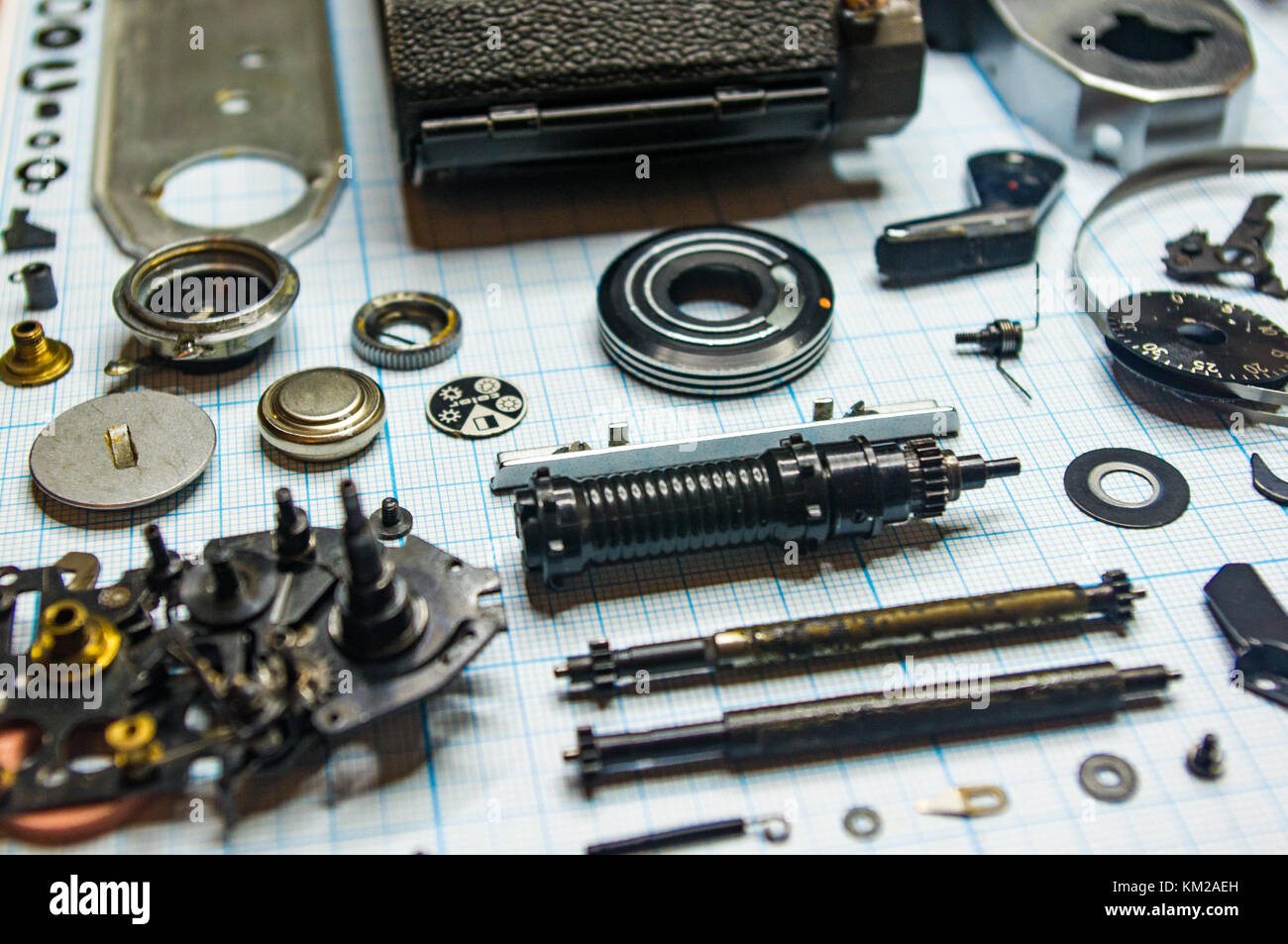 parts are completely disassembled old retro film SLR camera on graph ...