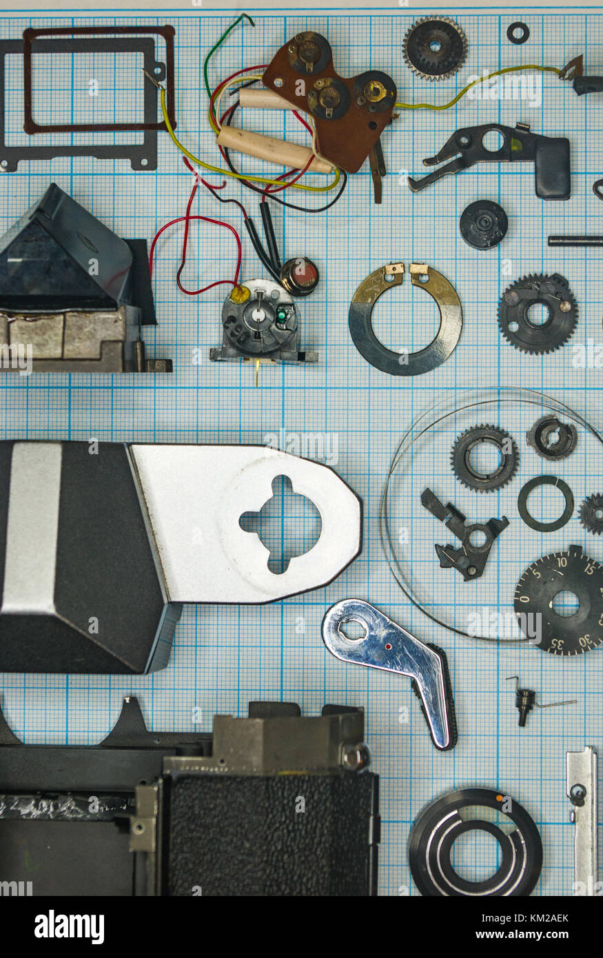 parts are completely disassembled old retro film SLR camera on graph ...