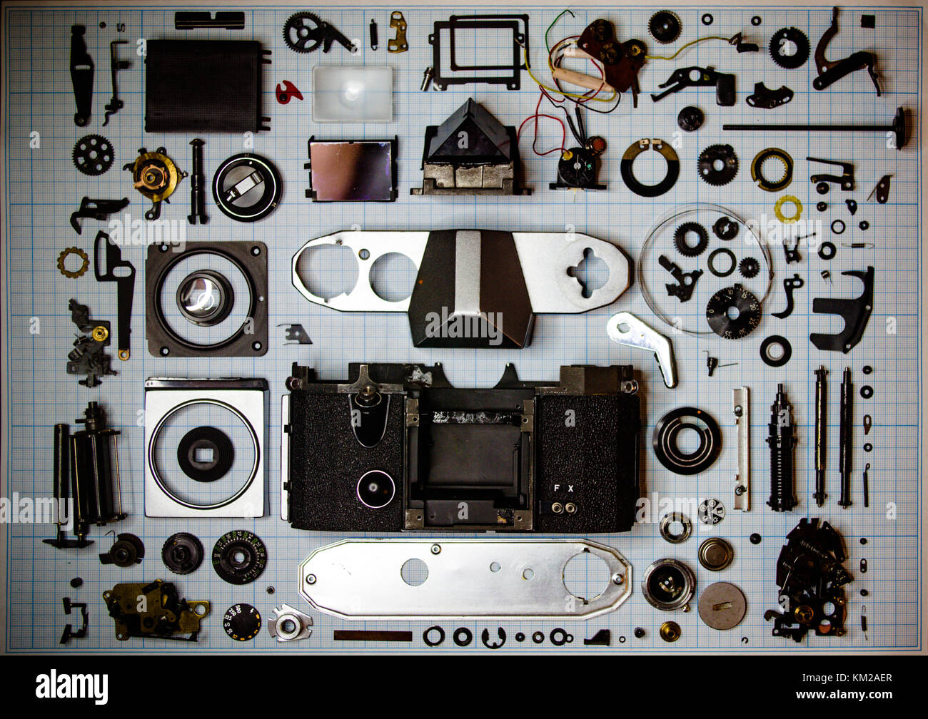 parts are completely disassembled old retro film SLR camera on graph ...