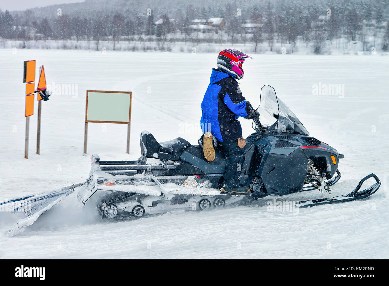 Man riding a snowmobile on the frozen lake at winter Rovaniemi, Lapland ...