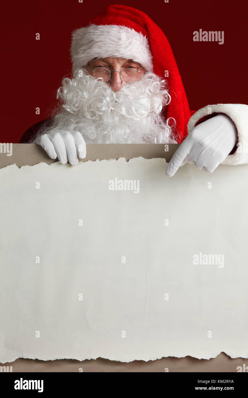 Santa Claus holding vintage paper billboard with copy space for text ...