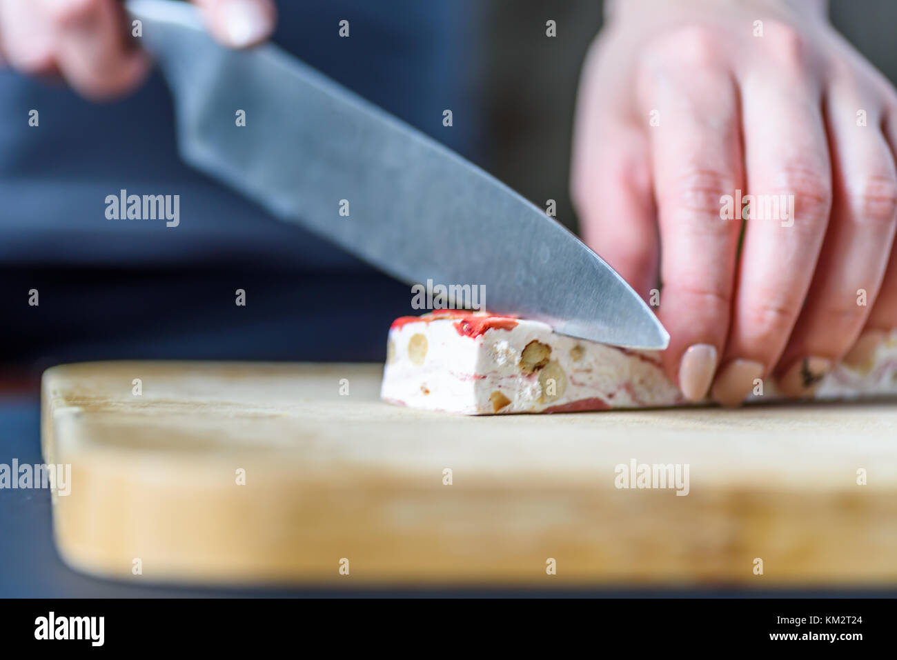 Female Hands Cutting Strawberry Fruit and Nut Nougat with Knife on ...