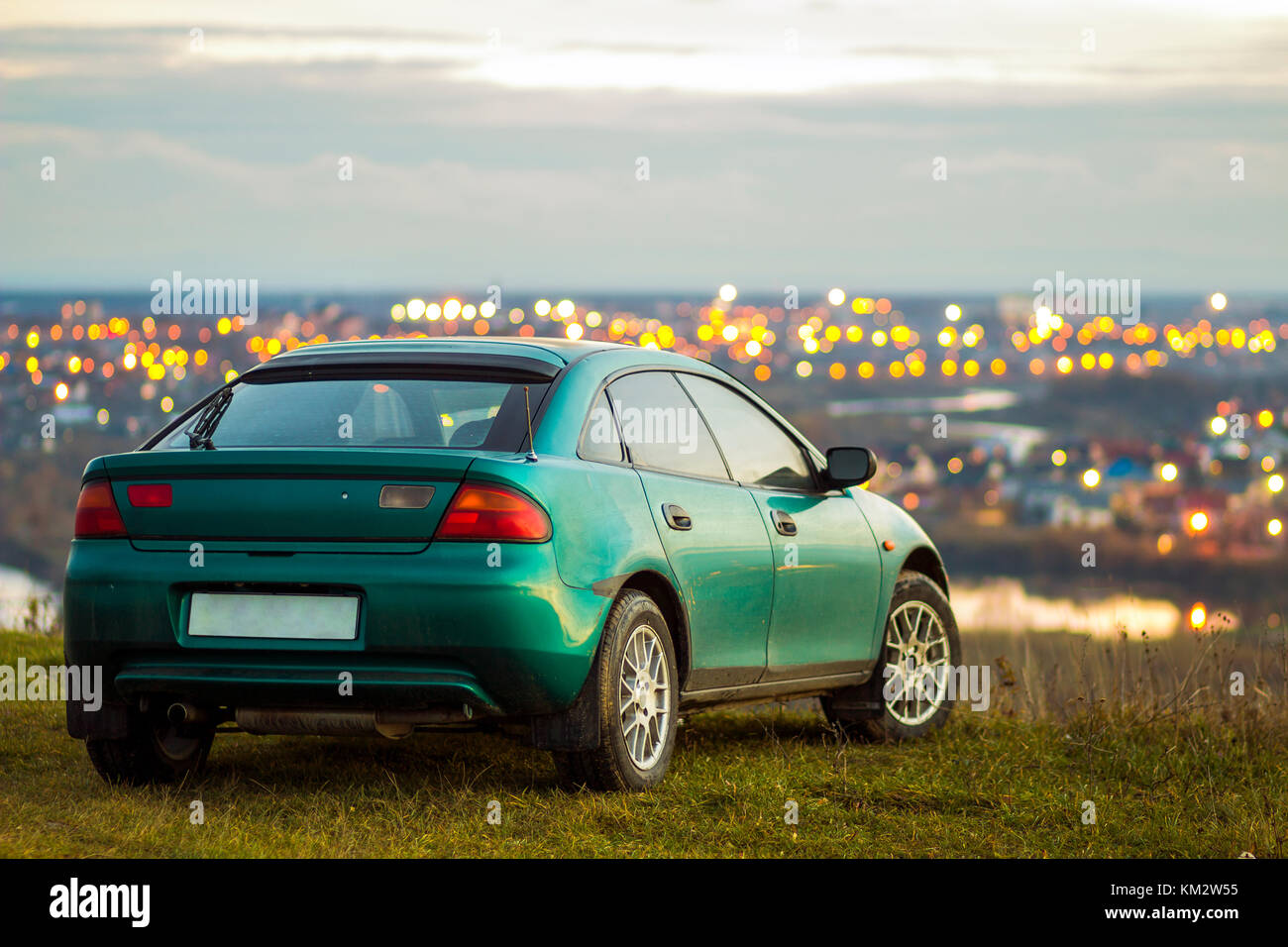 Modern car with blurred bright city lights behind Stock Photo - Alamy