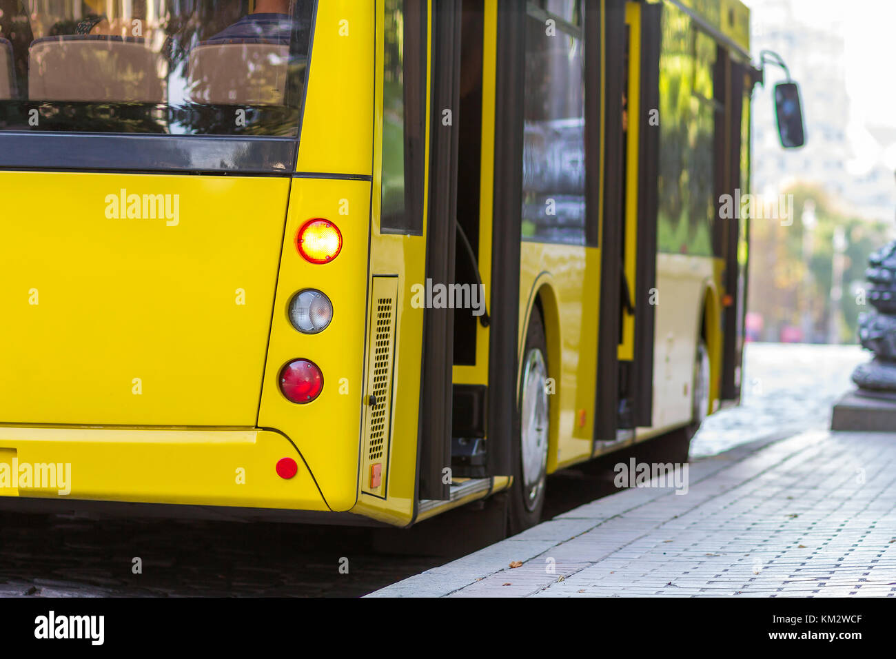 Modern yellow city bus with open doors at bus station Stock Photo - Alamy