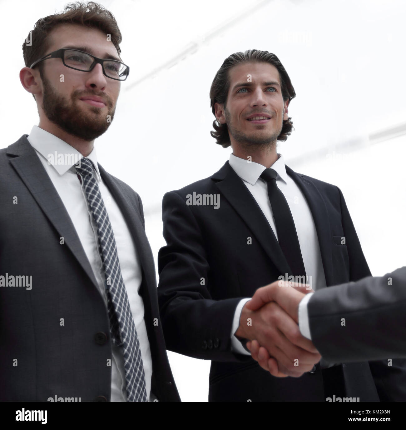business group welcomes partner with a handshake Stock Photo - Alamy