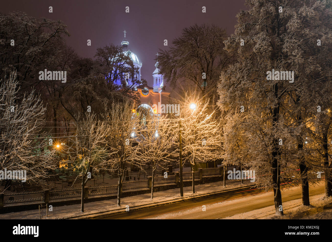 a church among the trees covered with snow in the night city Stock ...