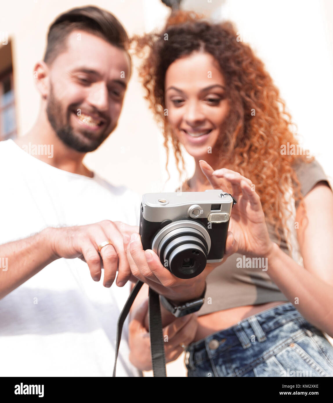 Portrait of young friends walking looking at the photos Stock Photo - Alamy